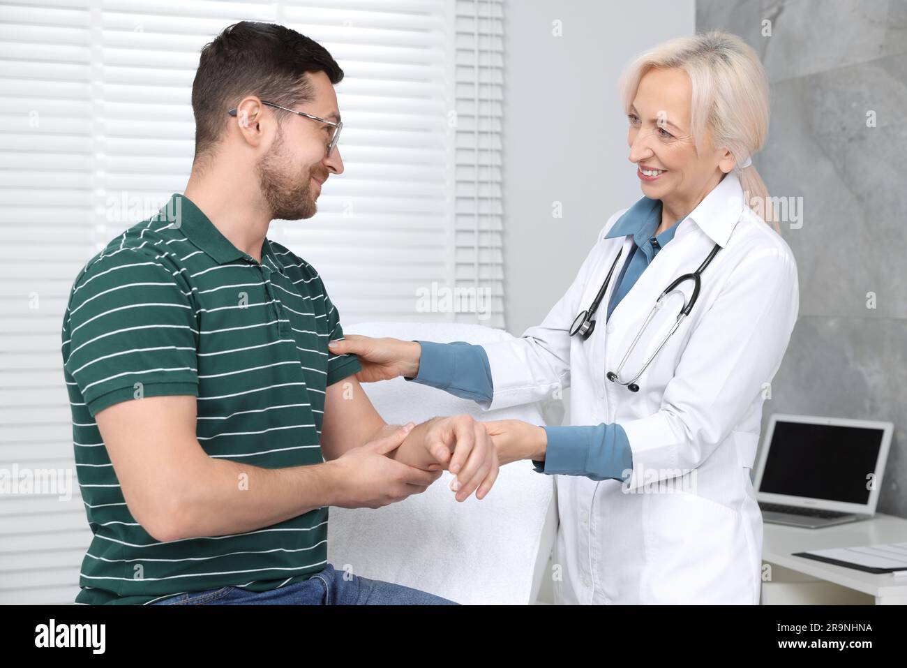 Doctor checking patient's pulse during consultation in clinic Stock ...