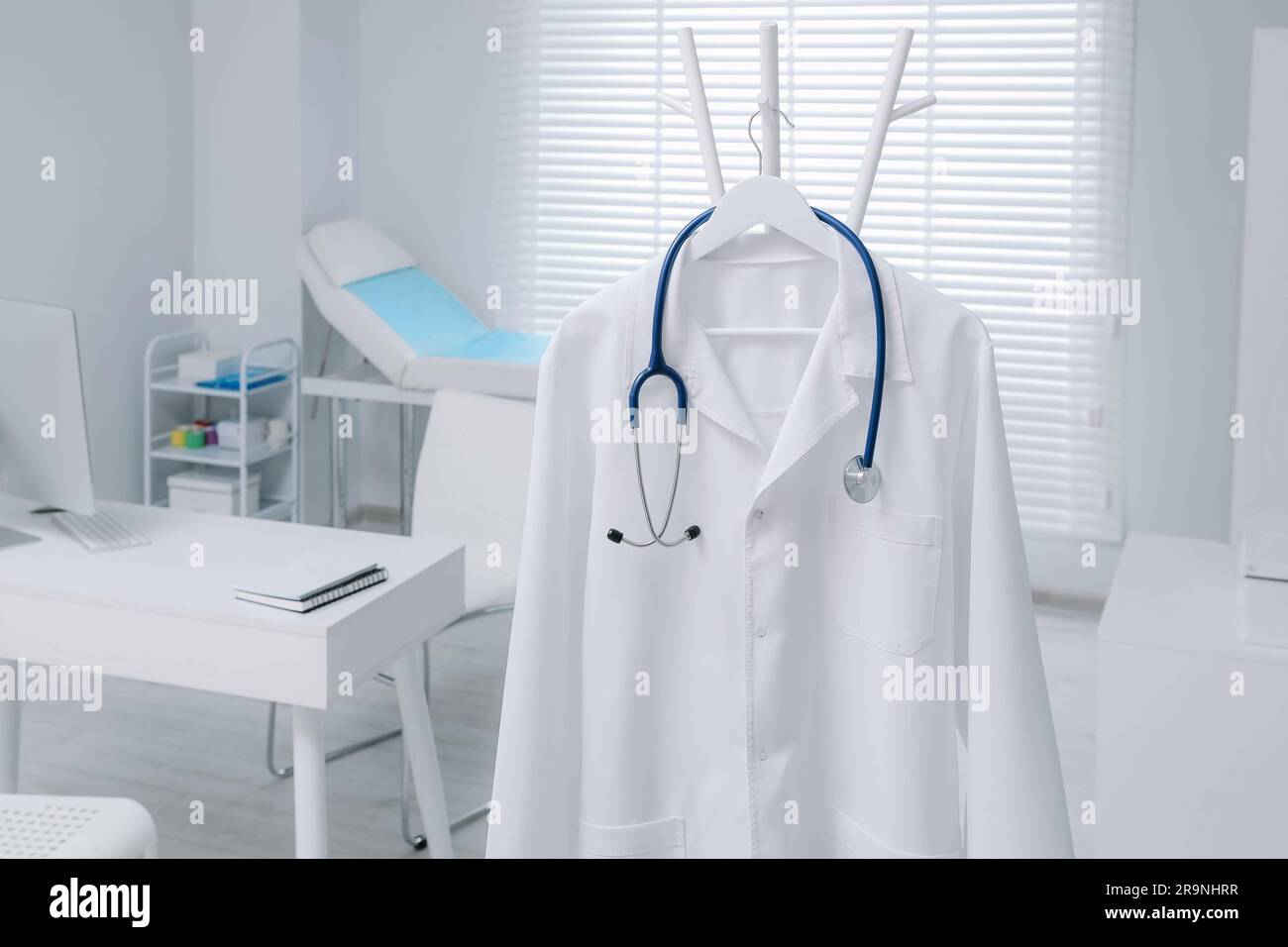 White doctor's gown and stethoscope hanging on rack in clinic Stock ...