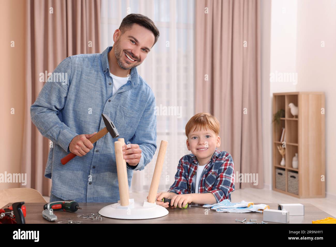 Father teaching son how to make stool at home. Repair work Stock Photo ...