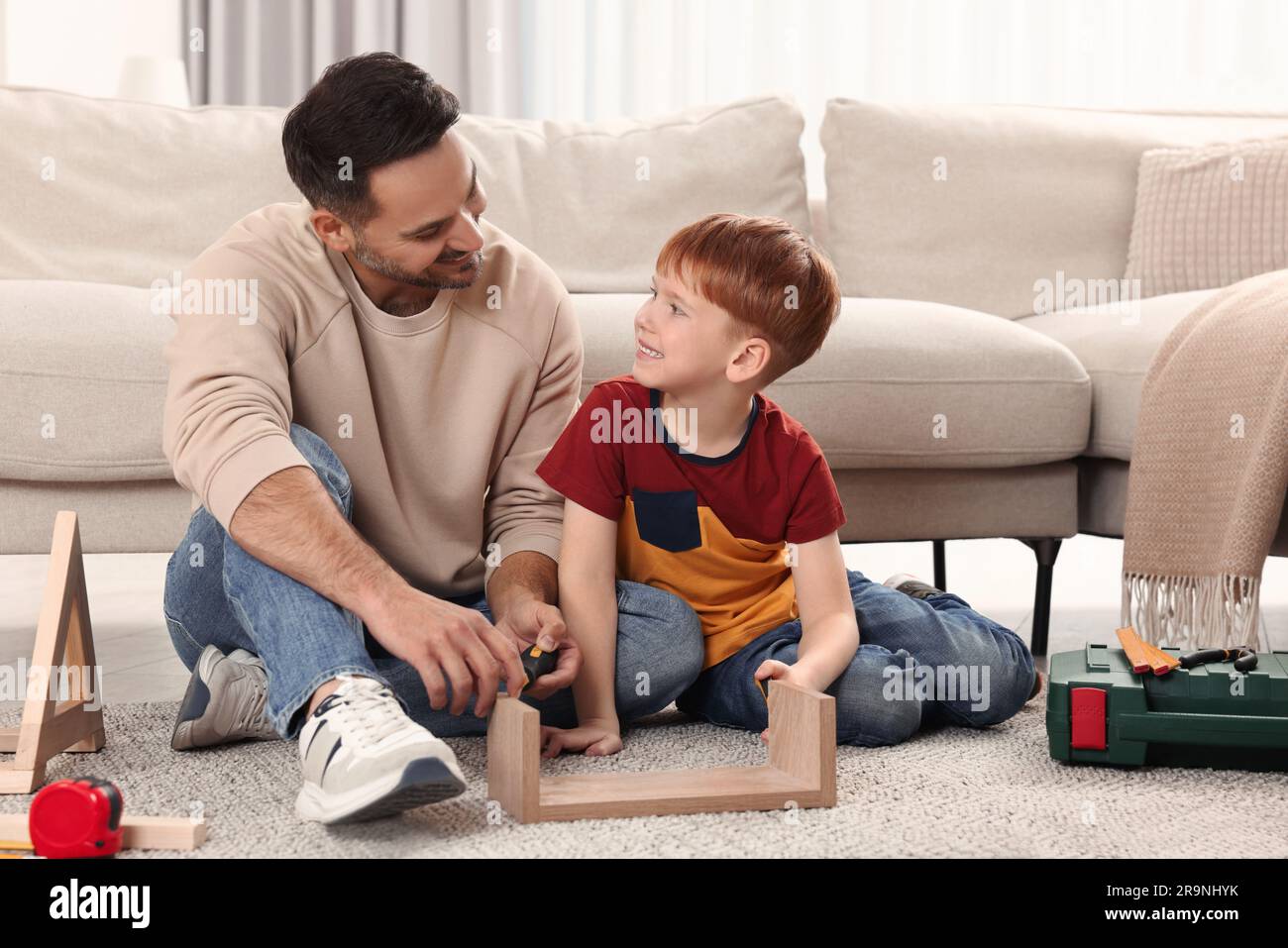 Father and son repairing shelf together at home Stock Photo - Alamy