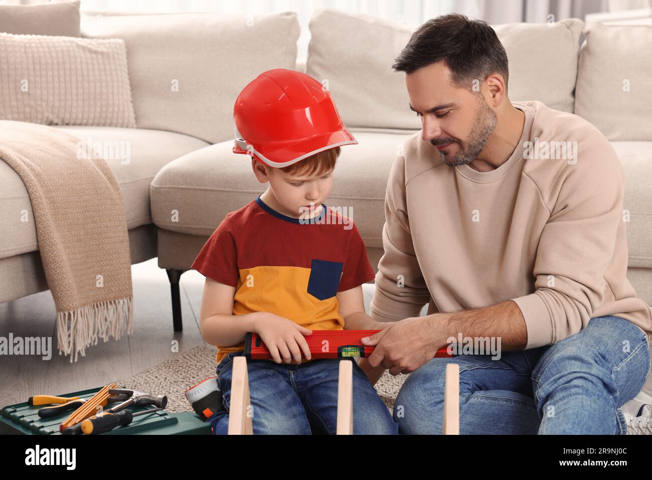 Father and son holding bubble level at home. Repair work Stock Photo ...