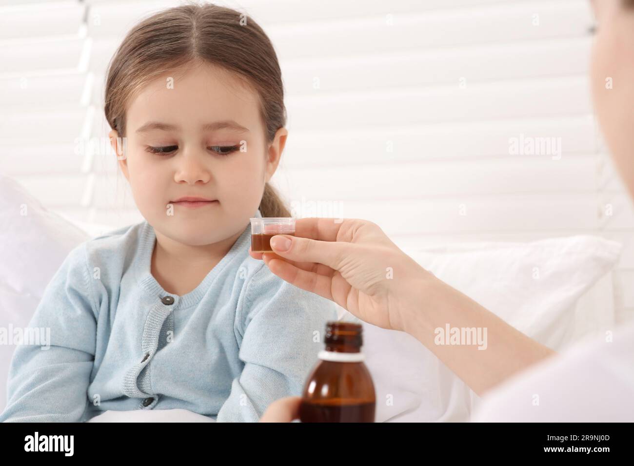Mother giving syrup daughter hi-res stock photography and images - Alamy