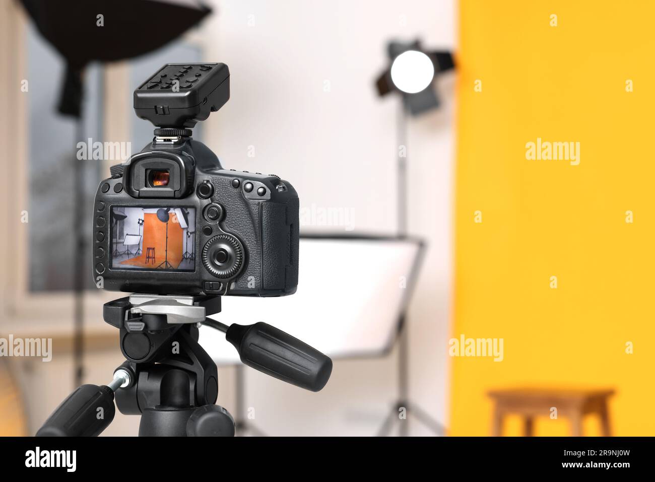 Tripod with camera, bar stool and professional lighting equipment in ...