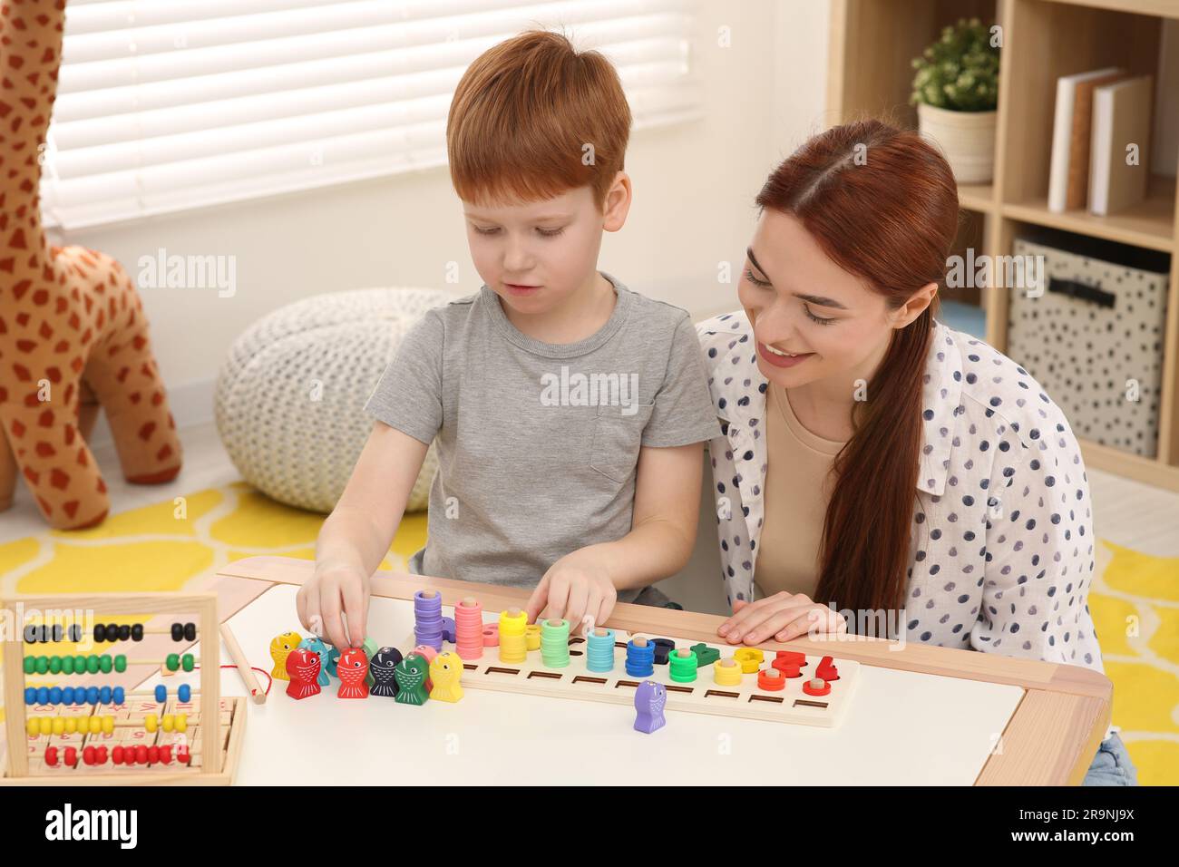 Happy mother and son playing with Educational game Fishing for Numbers ...