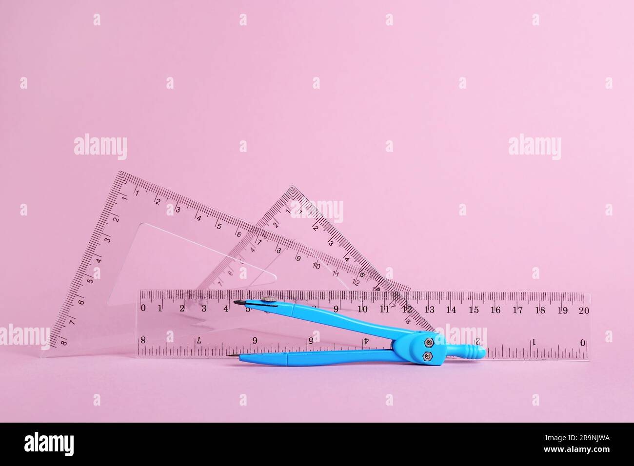 Different rulers and compass on pink background Stock Photo - Alamy