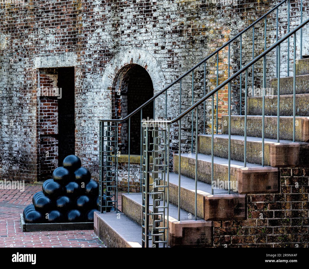 A staircase made of concrete leading up to a brick wall on the side of ...