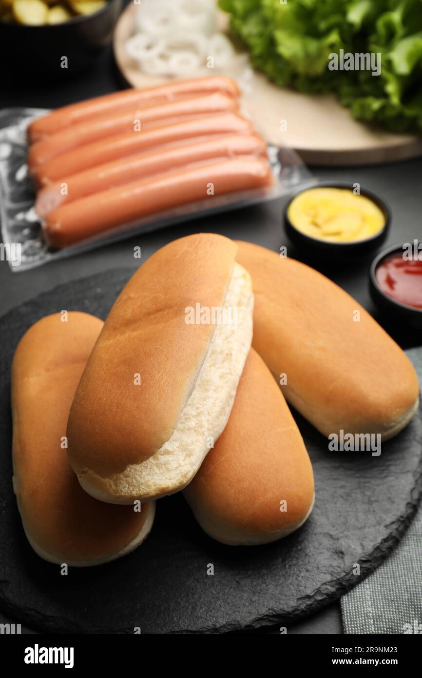 Different tasty ingredients for hot dog on dark table Stock Photo - Alamy