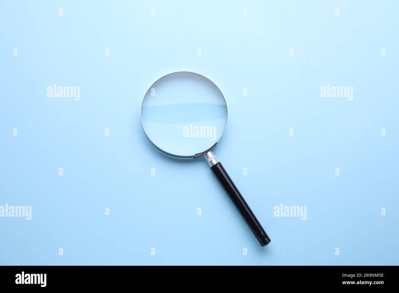 Magnifying glass on light blue background, top view Stock Photo - Alamy