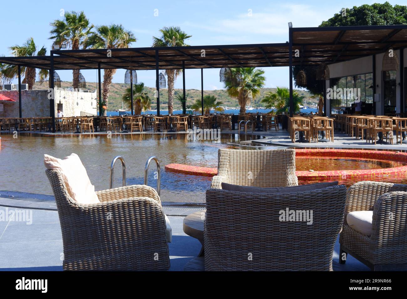 Wooden tables and chairs at poolside in a hotel Stock Photo - Alamy