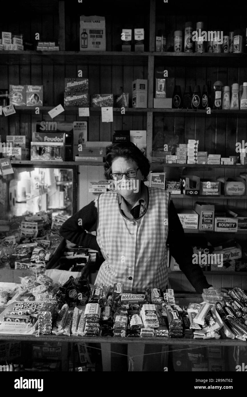 Shetlands daily life 1970s. Corner shop, woman behind the counter sweet ...