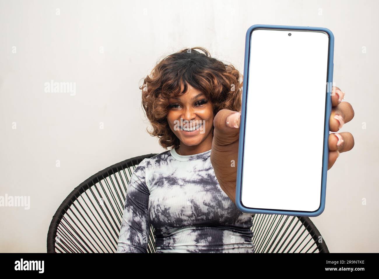 beautiful african lady showing a large phone screen Stock Photo - Alamy