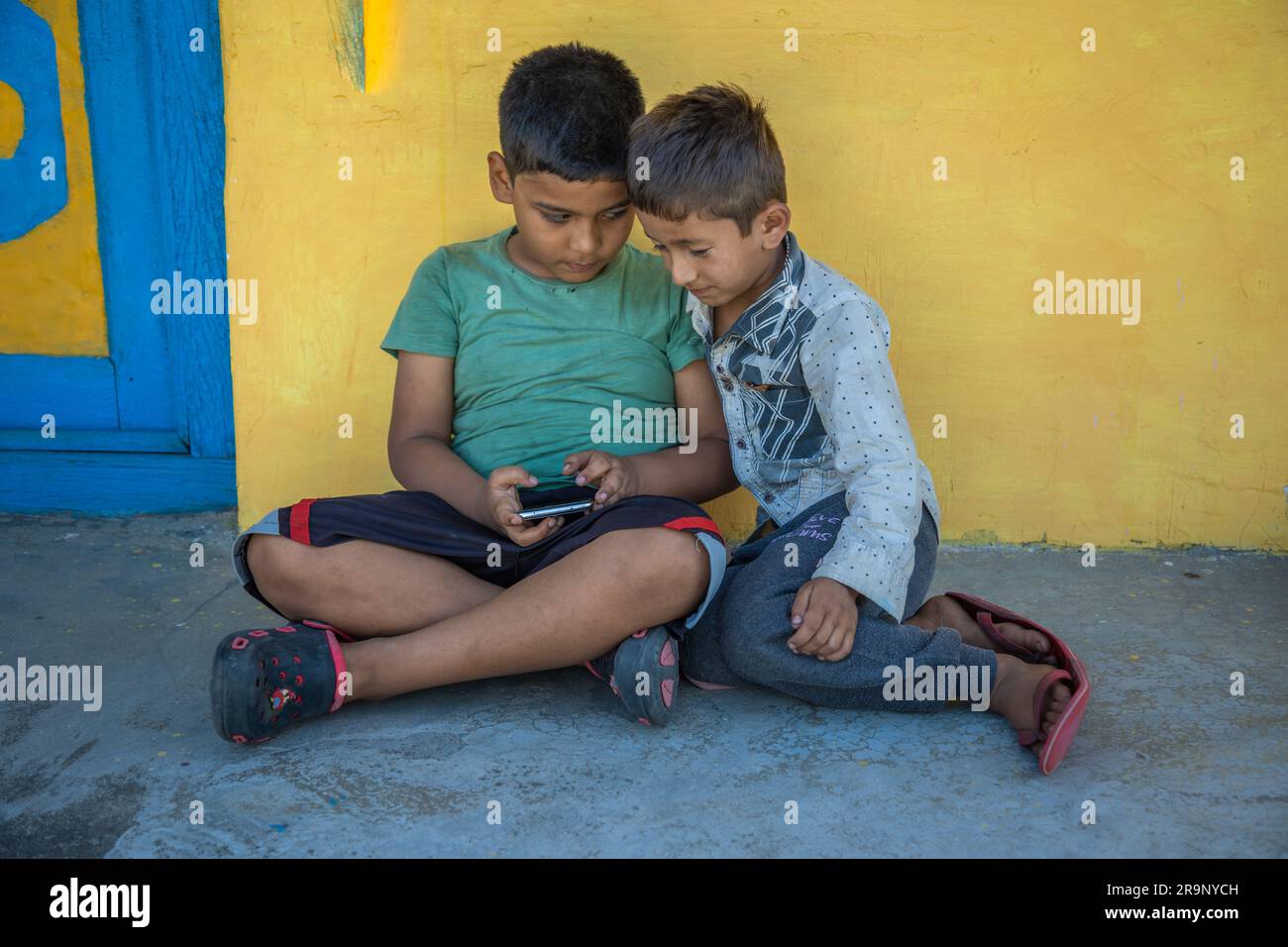 Indian village kids living in poverty using mobile phone - concept of ...