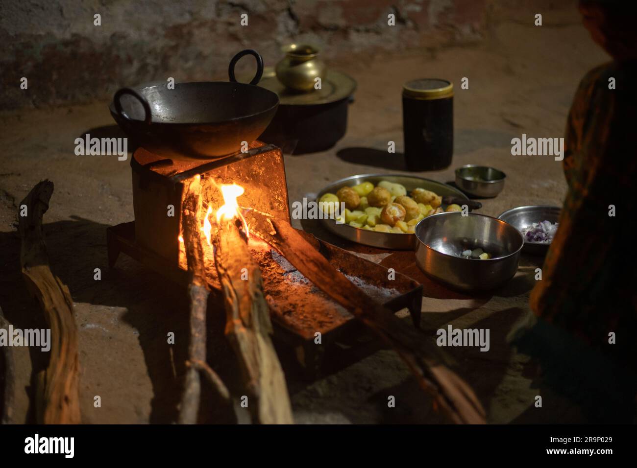Rural Woman cooking food at night in the courtyard of her house for ...