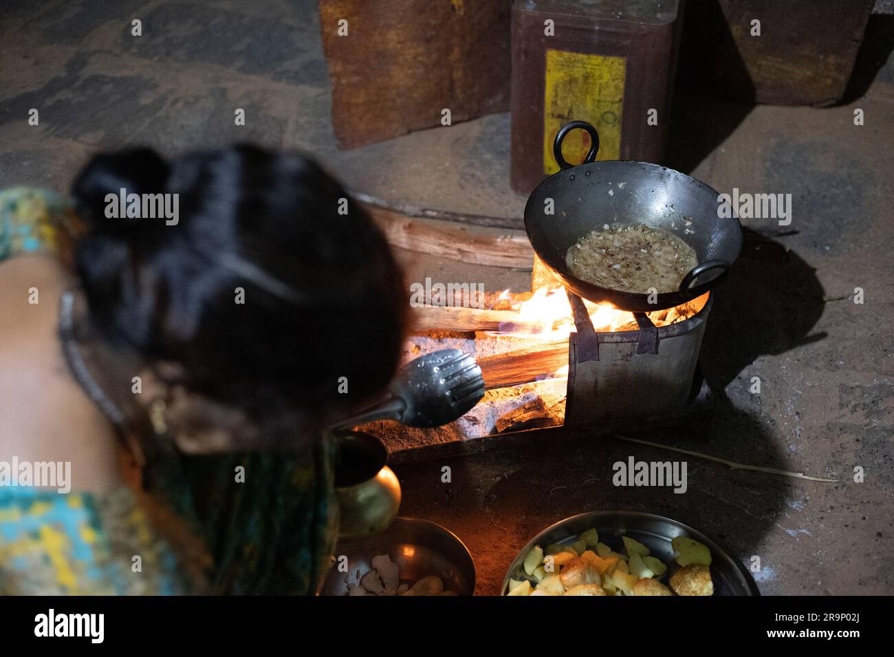 Rural Woman cooking food at night in the courtyard of her house for ...
