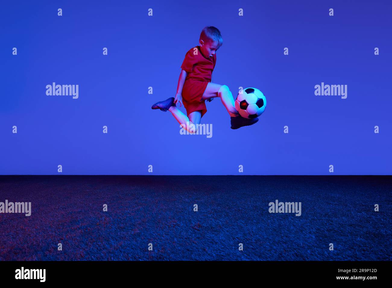 Male beginner soccer player in sports uniform in action, motion with ...