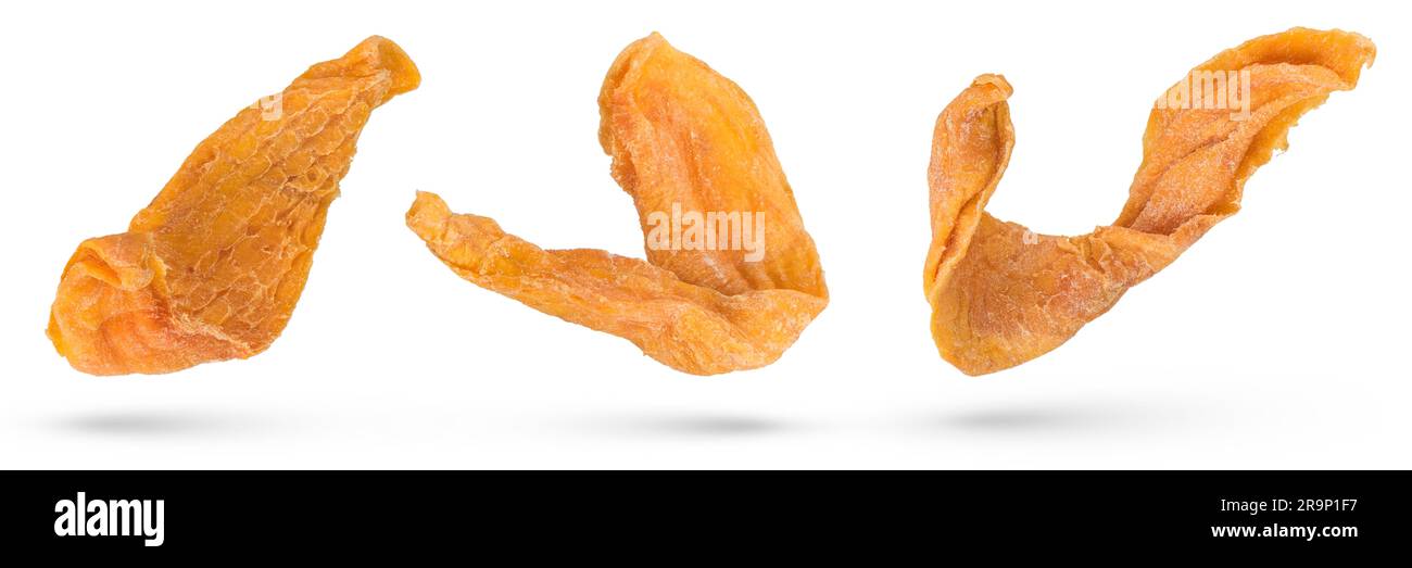 Flying dried fruits. Pieces of dried mango on a white isolated ...