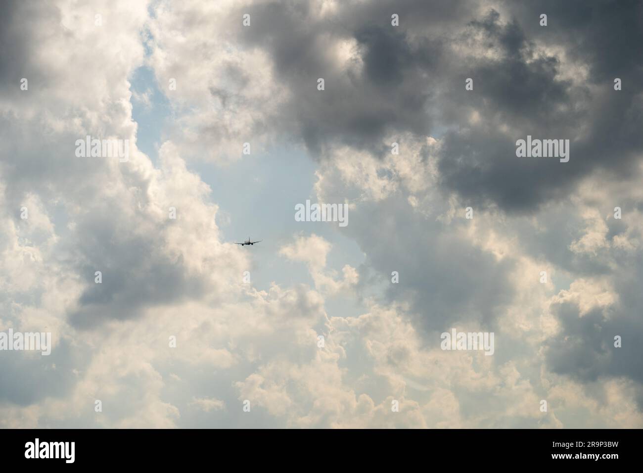 Passenger Plane Flying into the Clouds Stock Photo - Alamy