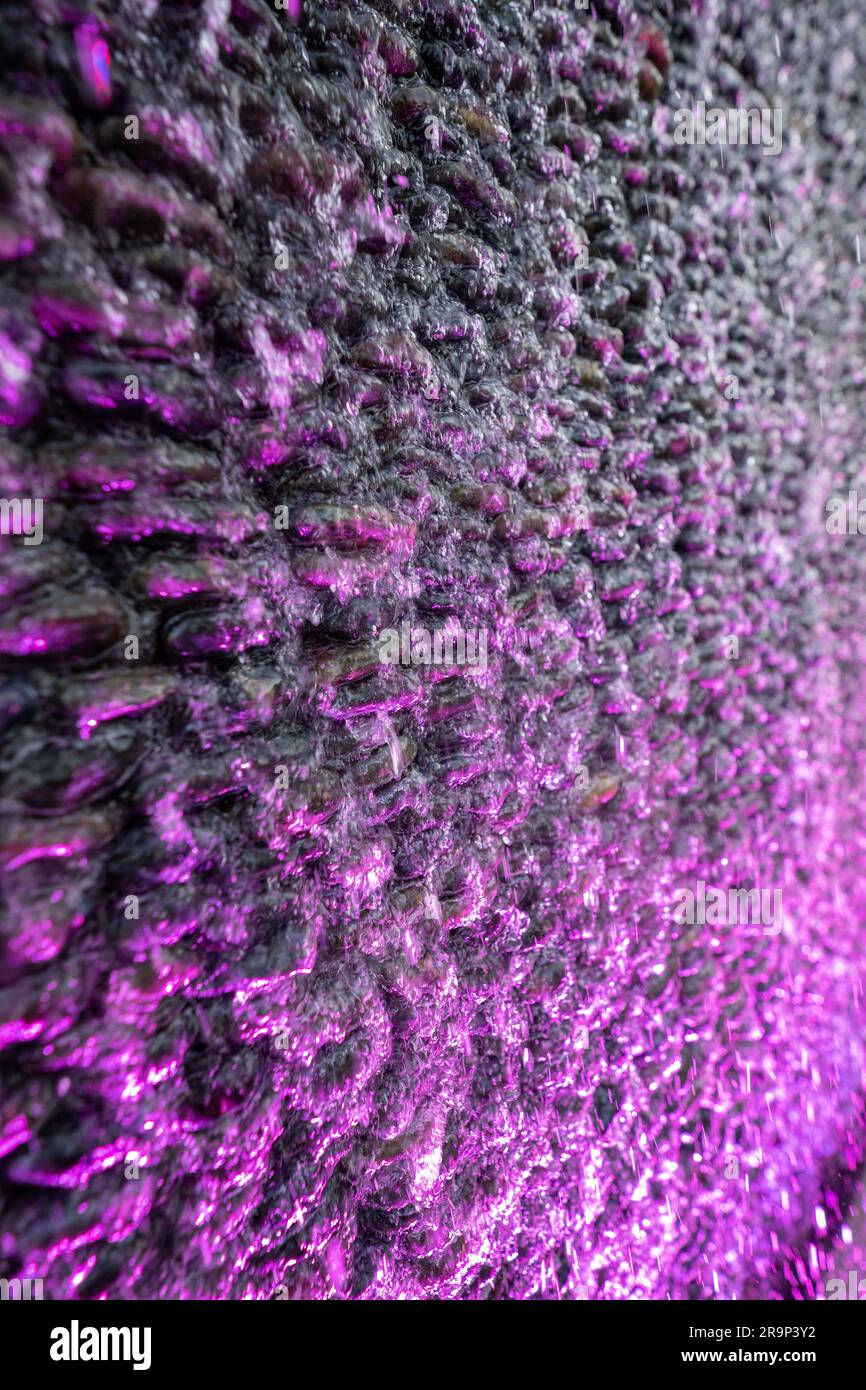 Water Running over an illuminated rock wall Stock Photo - Alamy