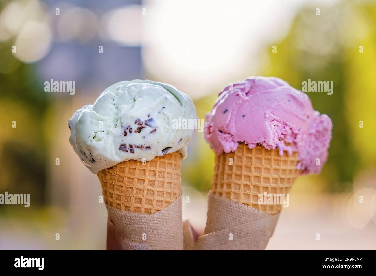 Two scoops of ice cream in hand. ice cream on a summer day outdoors ...