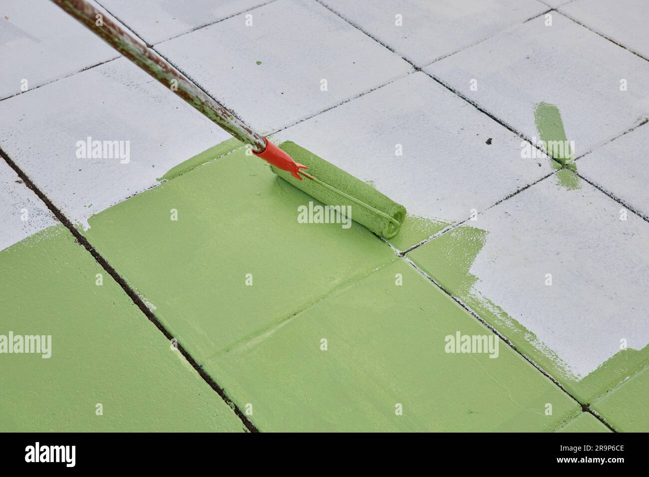 Paint roller and painting green color on footpath Stock Photo - Alamy