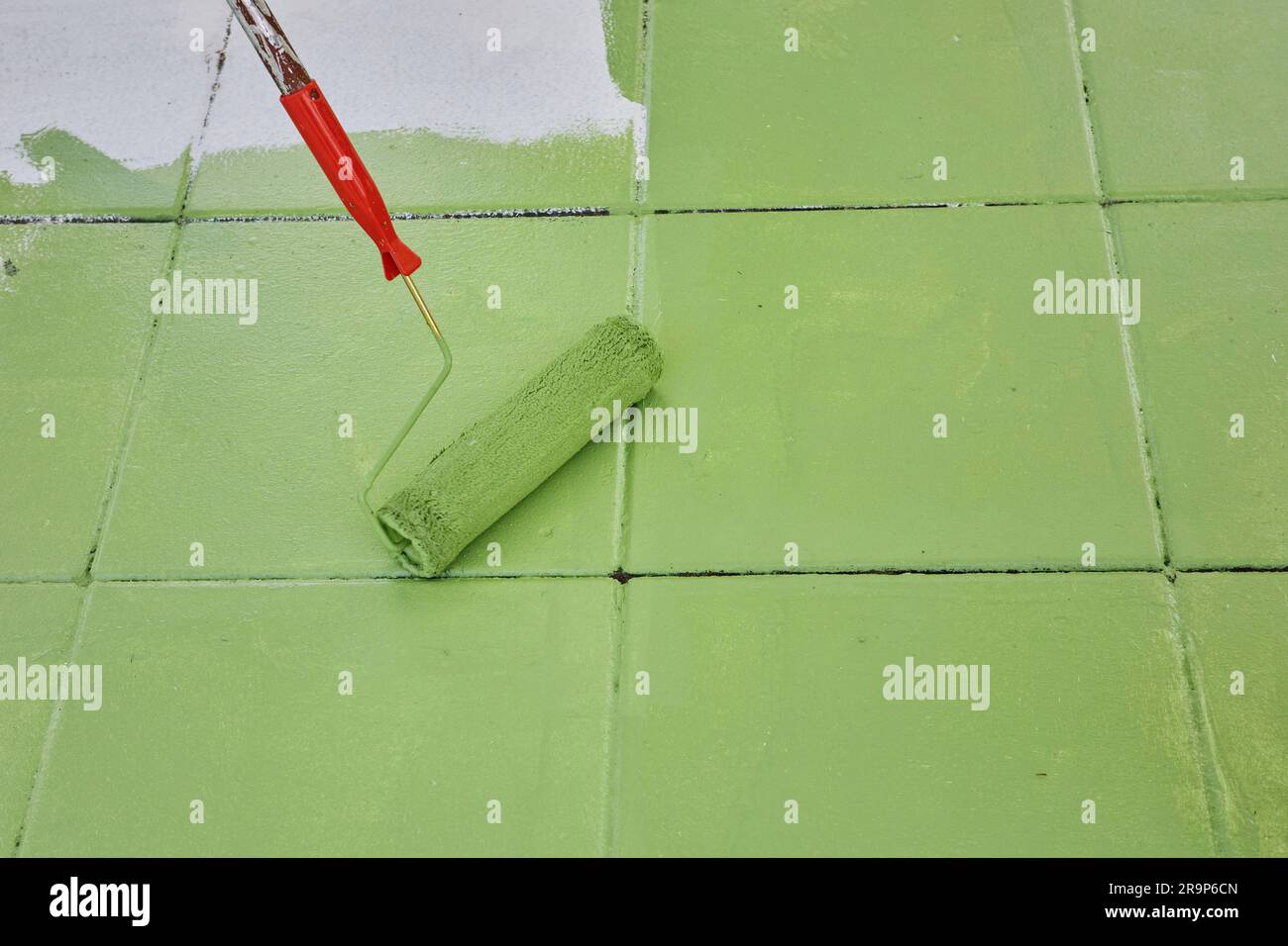 Paint roller and painting green color on footpath Stock Photo - Alamy
