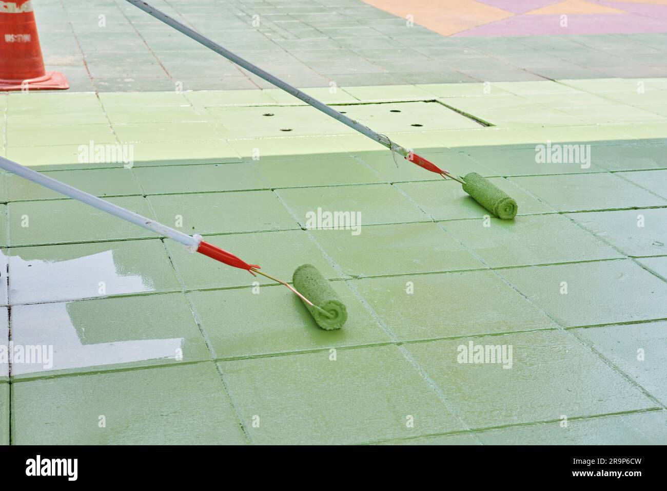 Paint roller and painting green color on footpath Stock Photo - Alamy