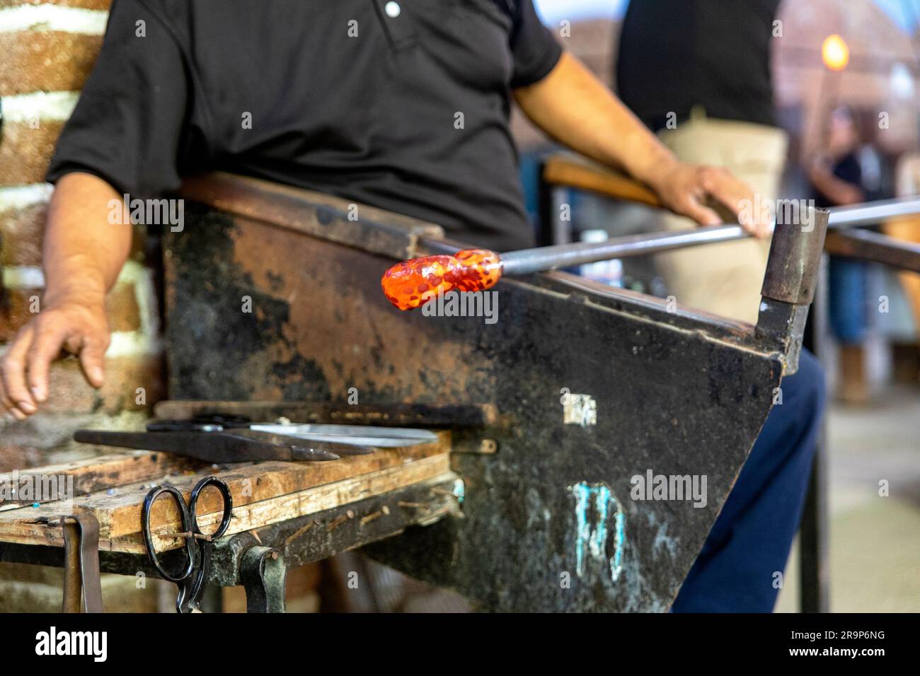 Craftsman working and molding the glass with the traditional method of ...
