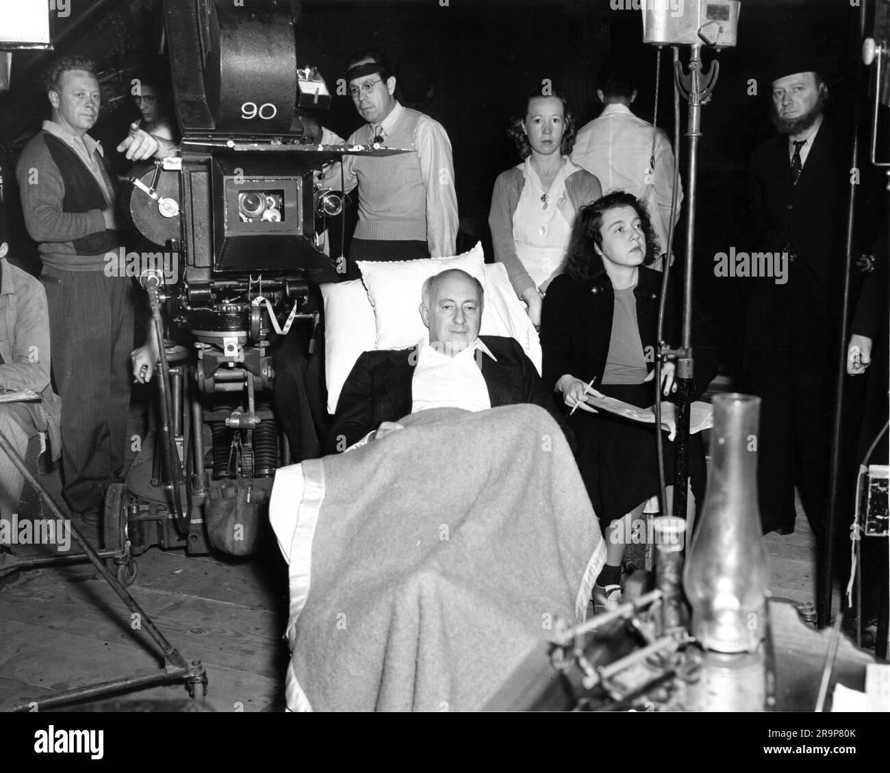CECIL B. DeMILLE directing from his sick bed with long time secretary ...