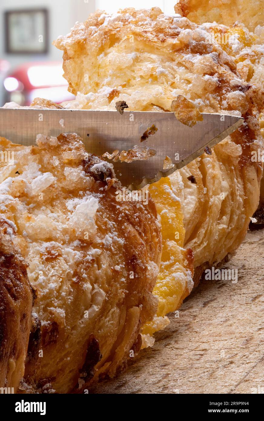 Close up of a sacristain, traditional french pastry being cut on a ...