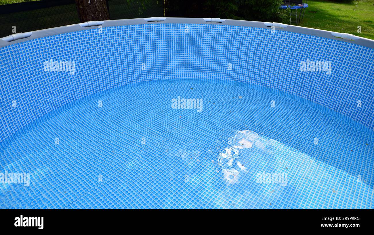 Water flowing from the hose into the pool filling. The inside of the ...