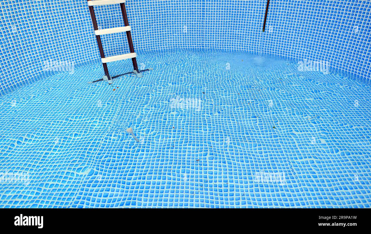 Water flowing from the hose into the pool filling. The inside of the ...
