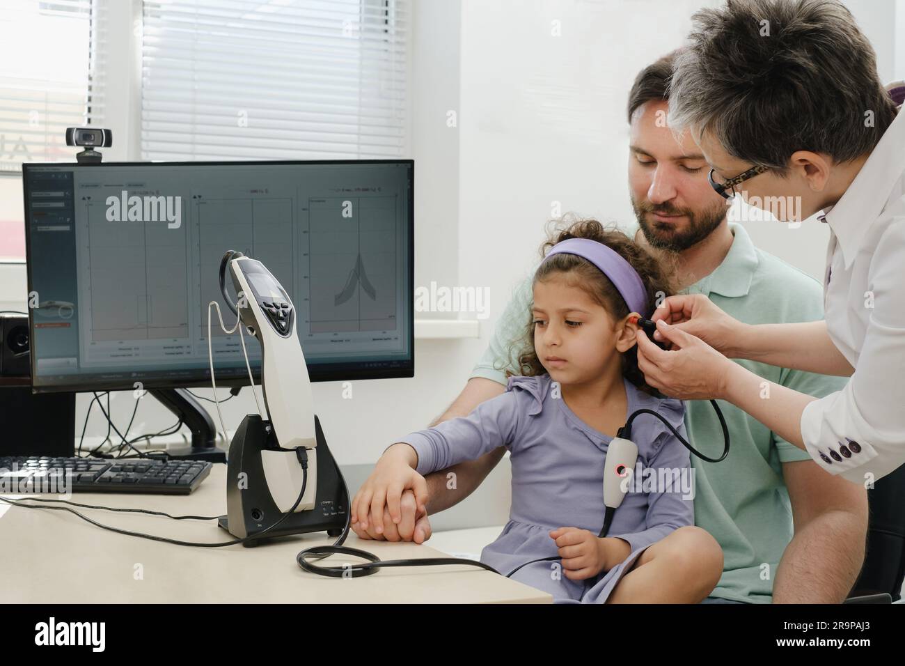 Child hearing test. Doctor audiologist consulting father of girl ear ...