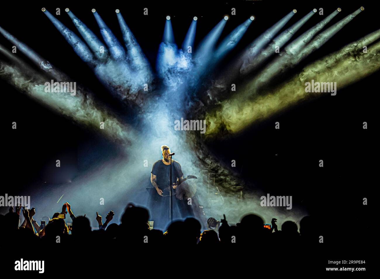 A performer on a professional stage with illuminated spotlights and ...