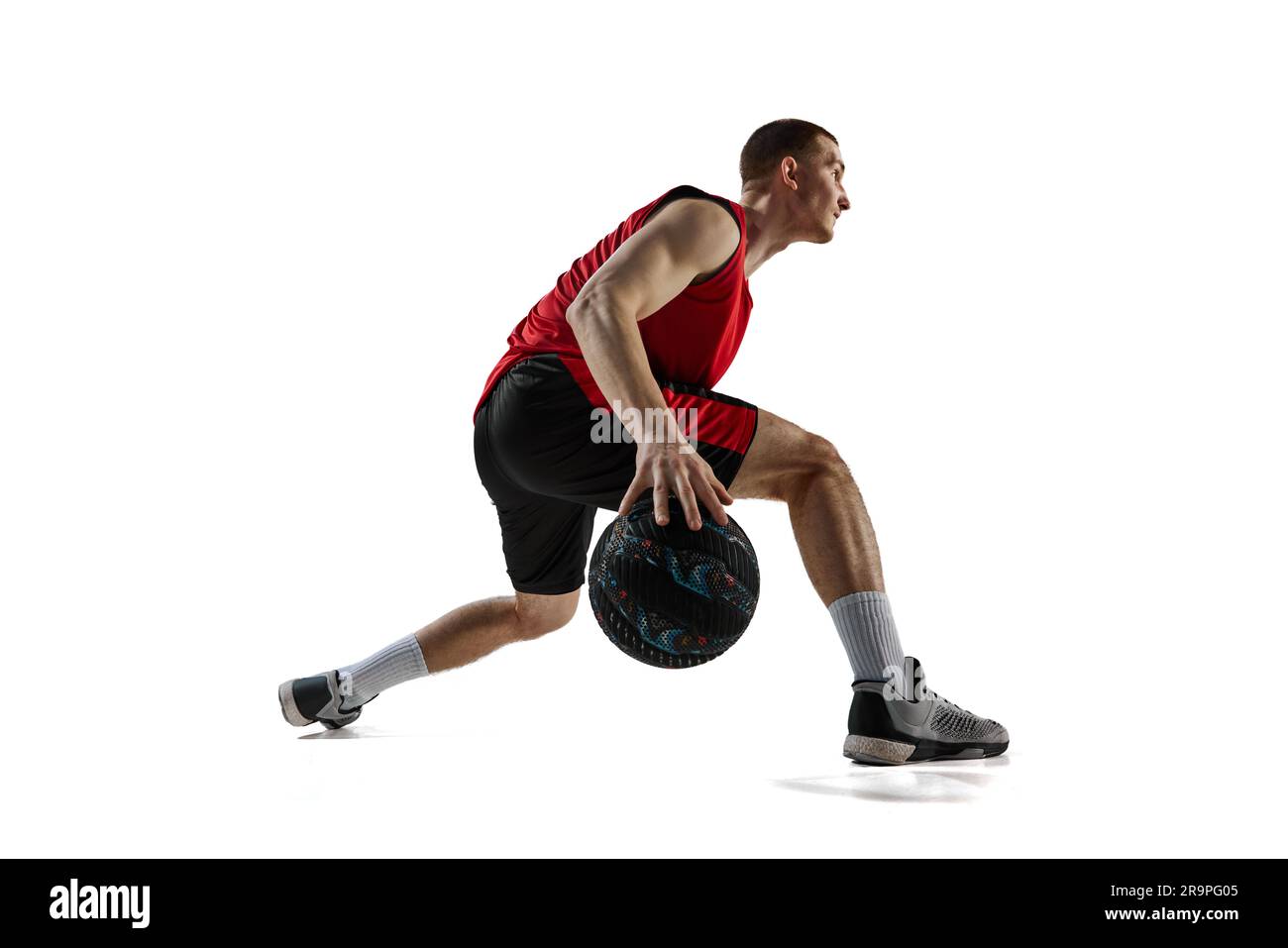 Dribbling. Young concentrated man, basketball player in motion during ...