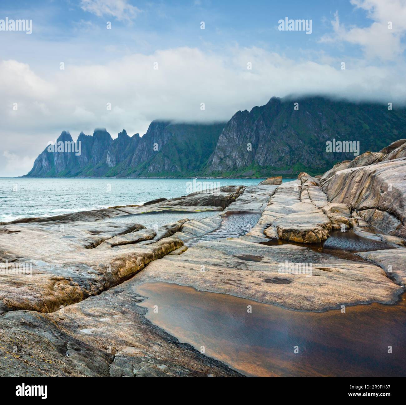 Stony beach with tidal baths at Ersfjord, Senja, Norway. Summer polar ...