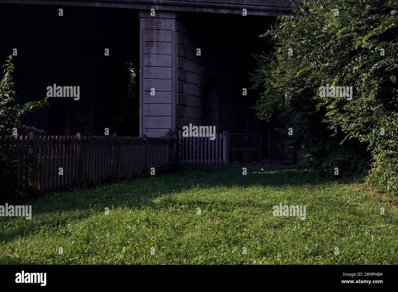 Gate in a lawn under a bridge next to a railroad track in a park at ...
