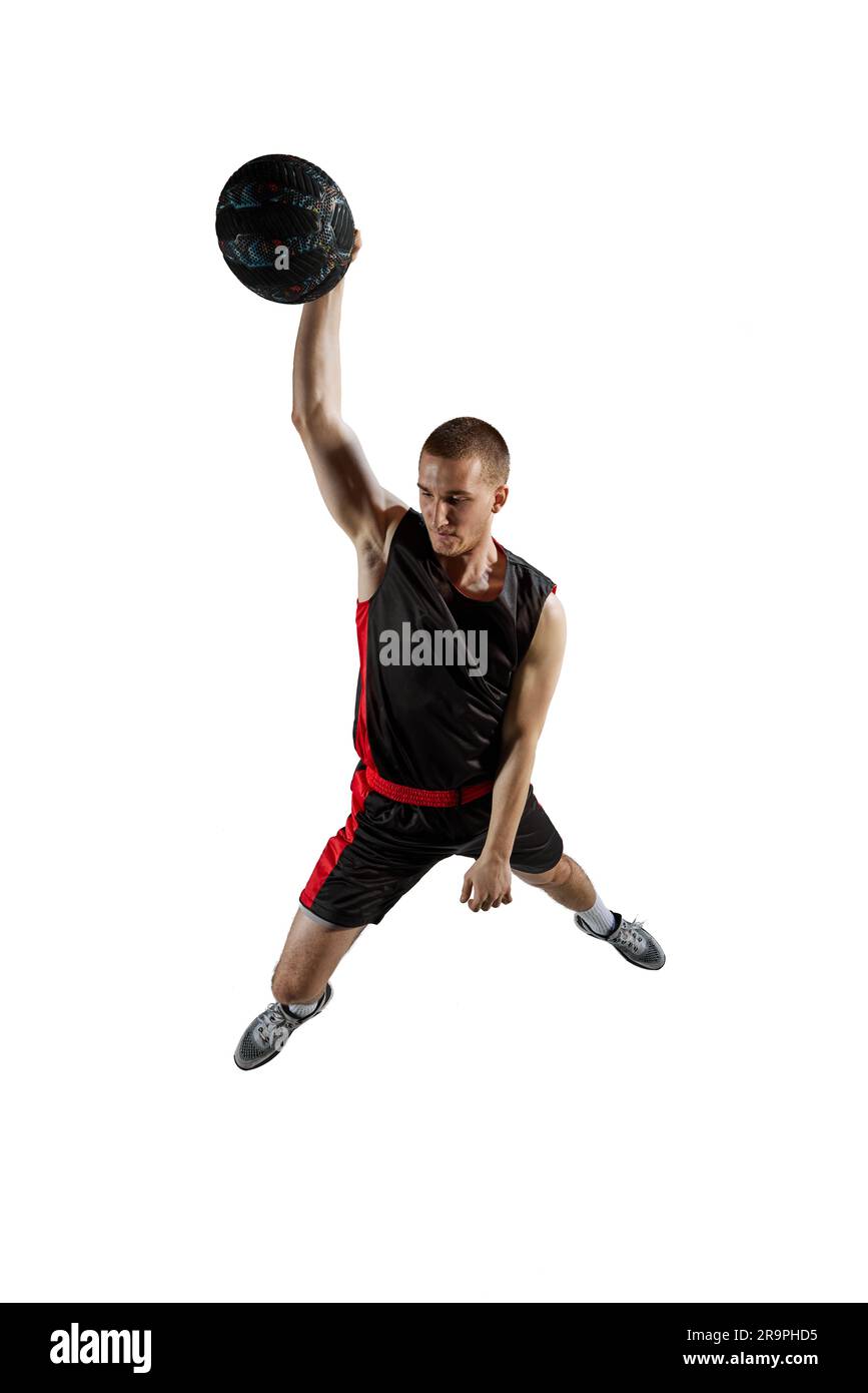 Slam dunk. Full-length dynamic image of young man, basketball player in ...