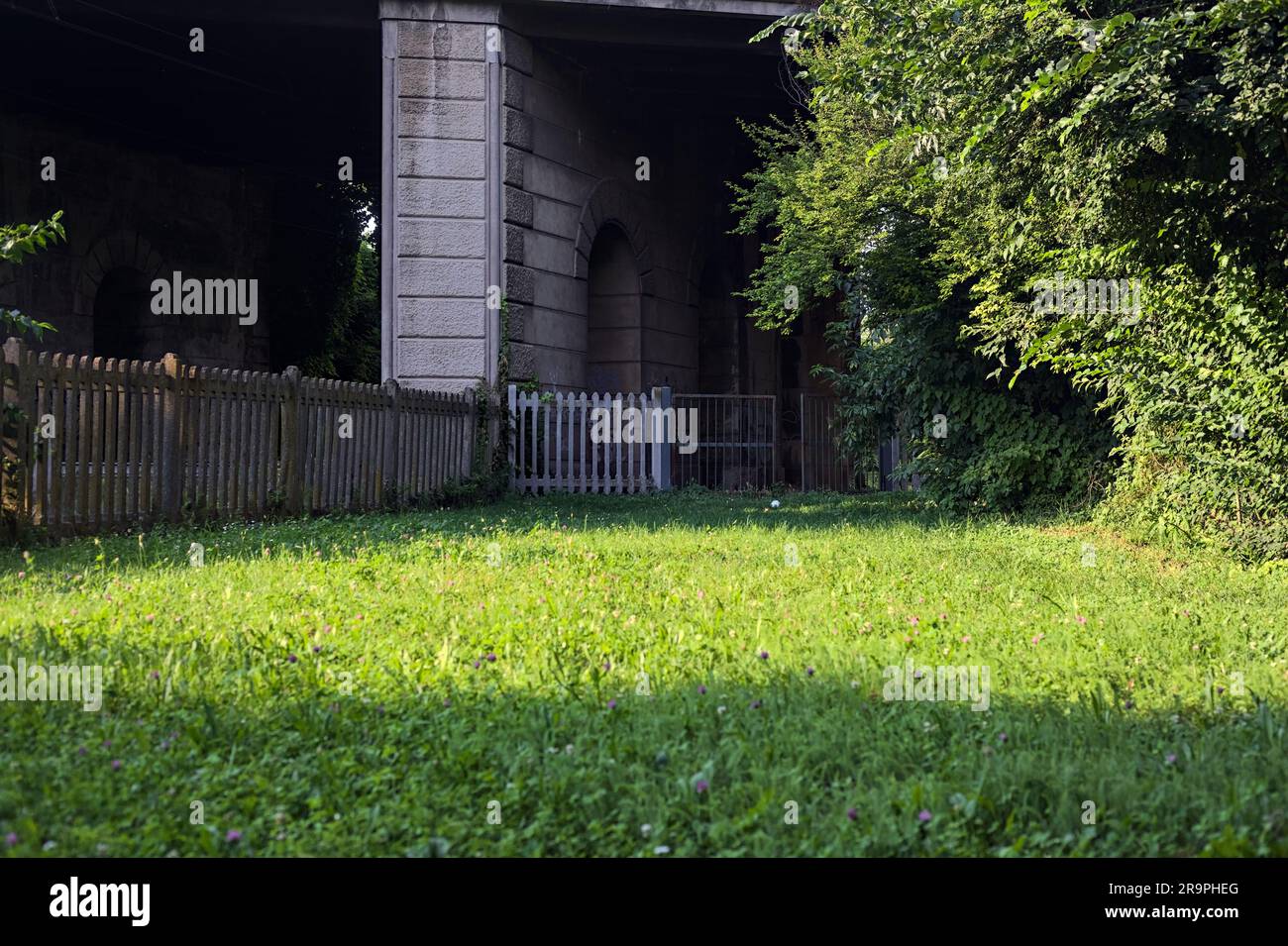 Gate in a lawn under a bridge next to a railroad track in a park at ...
