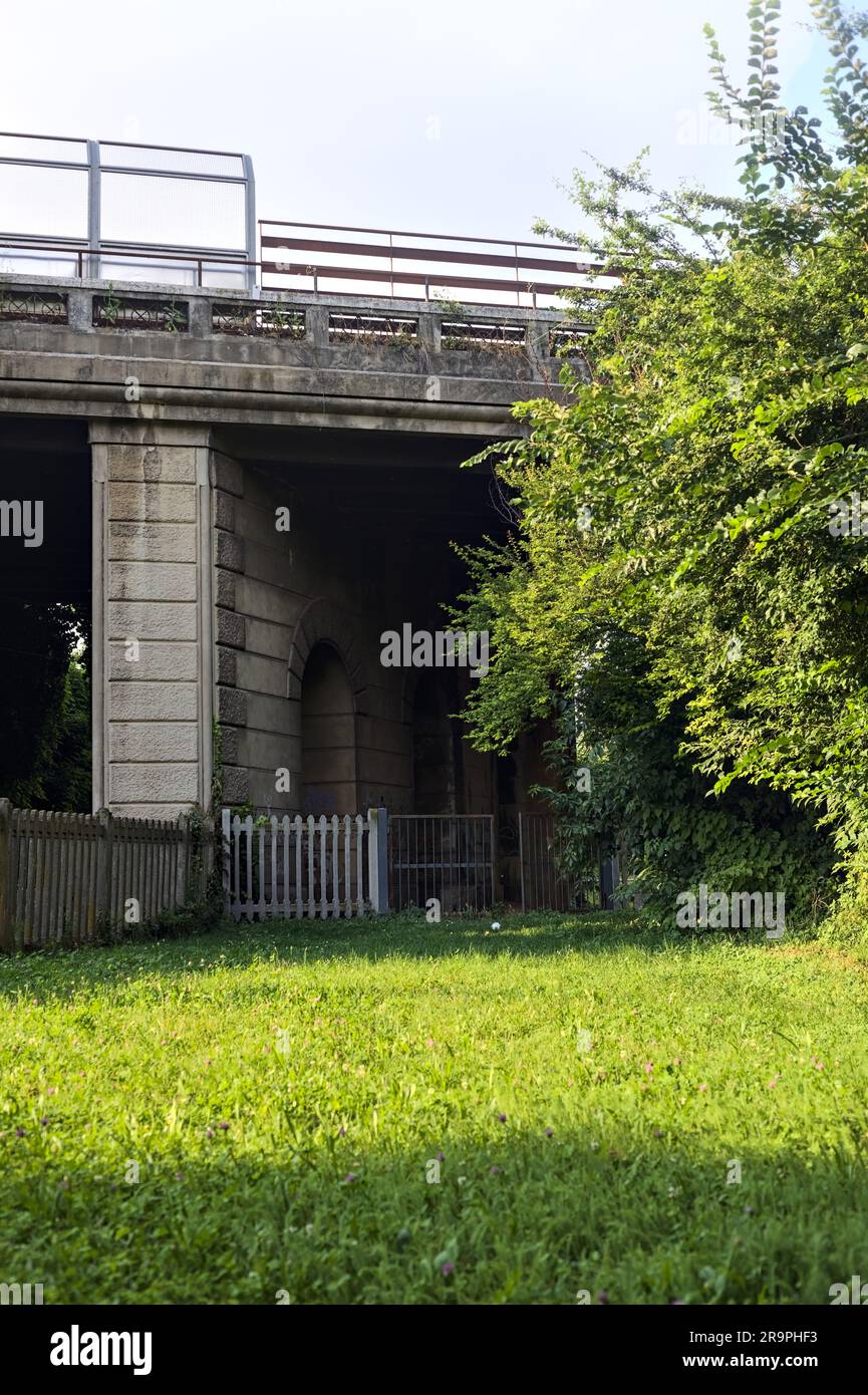 Gate in a lawn under a bridge next to a railroad track in a park at ...