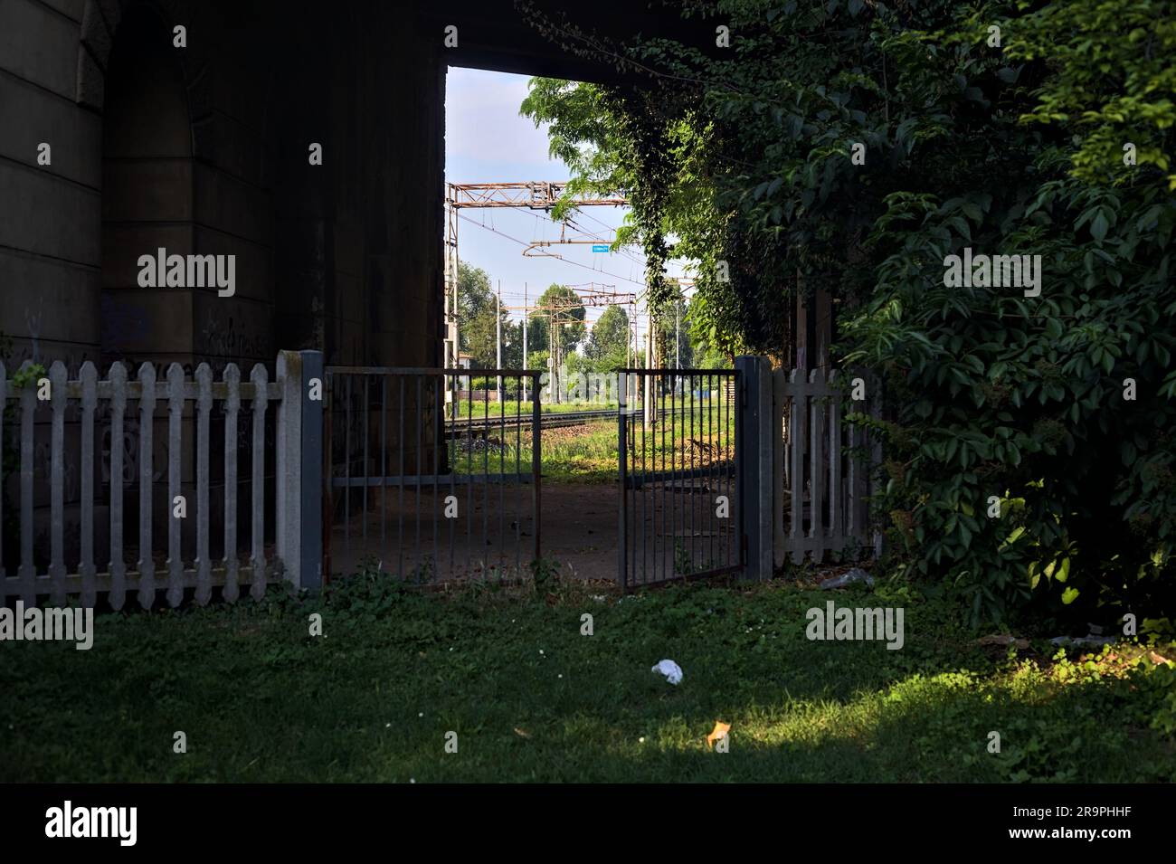 Gate in a lawn under a bridge next to a railroad track in a park at ...
