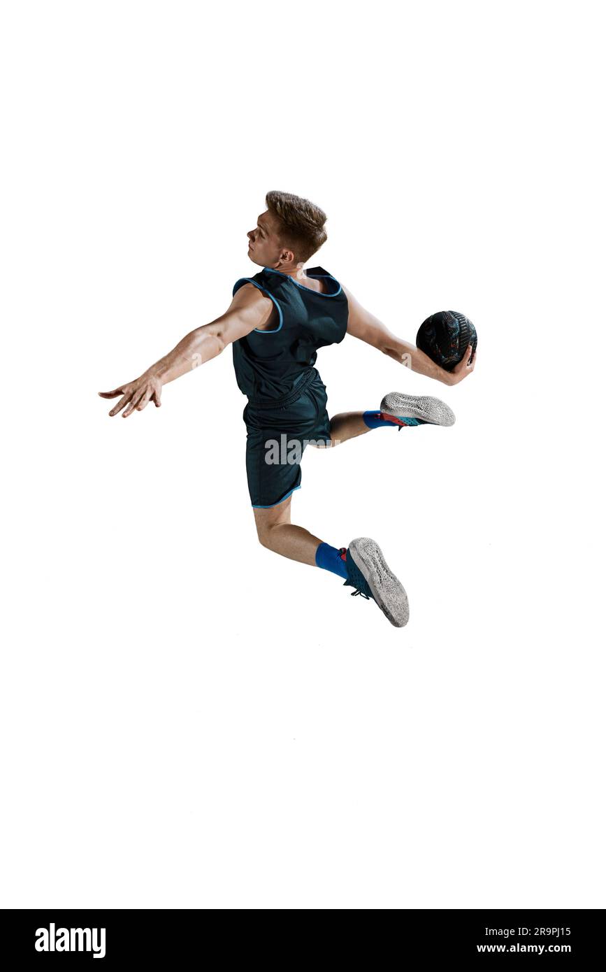 Full-length image of young man, basketball player in jump with ball ...