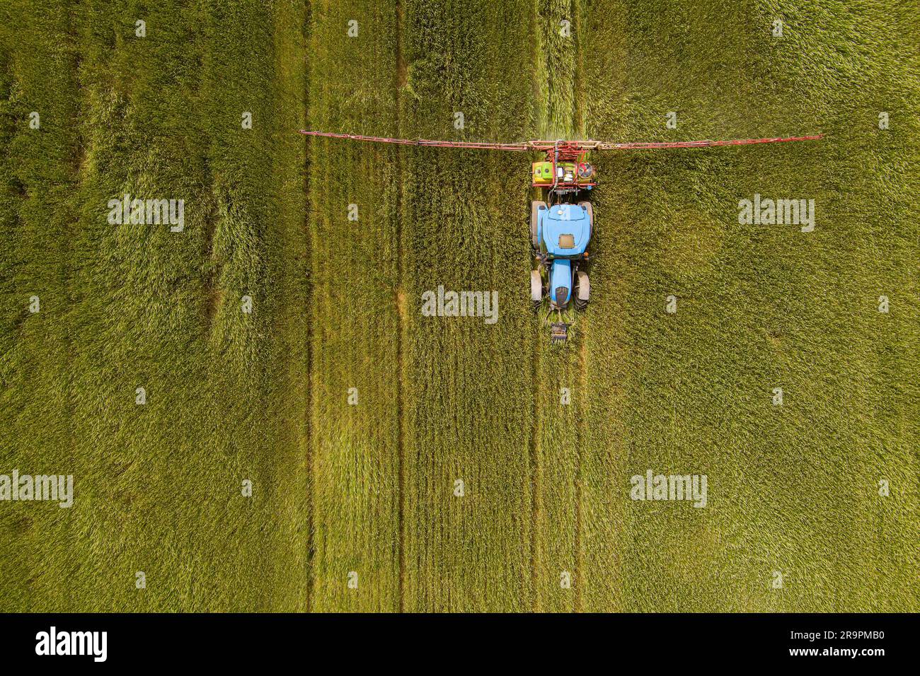 Aerial view of a tractor spraying agricultural fields. spraying ...
