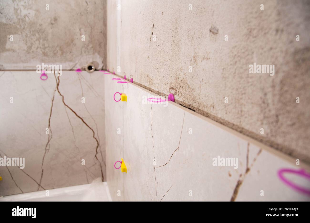 Laying porcelain tiles on the wall in the bathroom. Modern tile ...