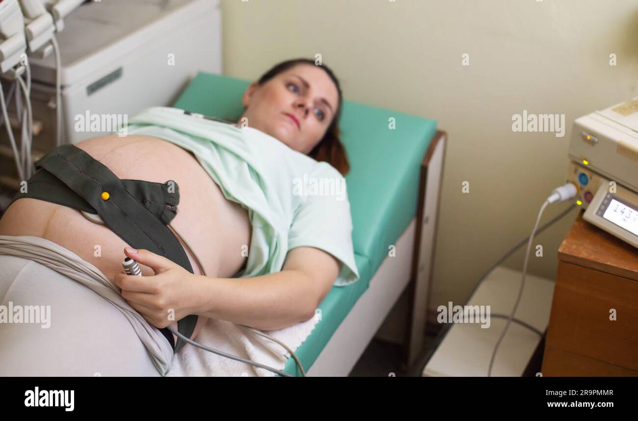 A pregnant woman undergoes a medical examination. Cardiotocography for ...