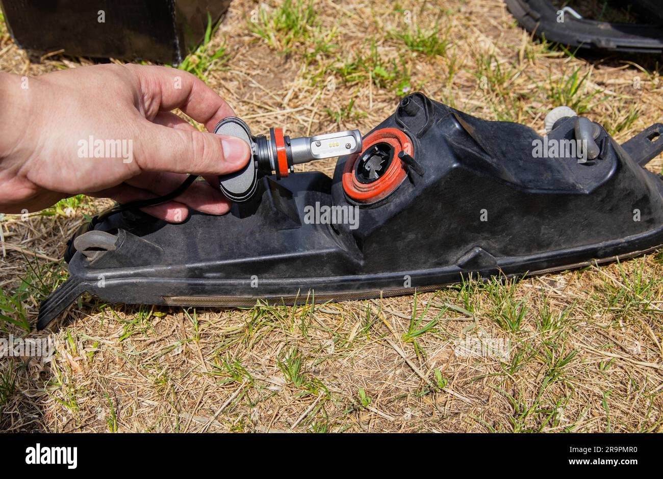 Replacing a burned out light bulb in a car headlight with an LED lamp ...