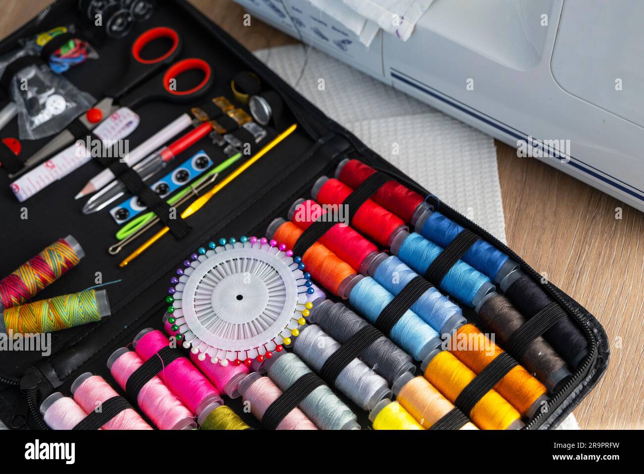 Sewing layout with multicolored spools of thread close-up, needles ...