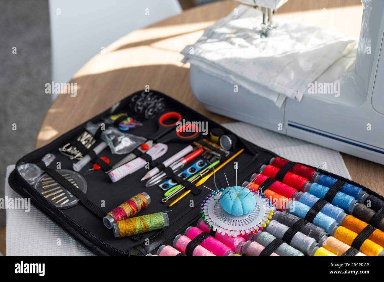 Sewing layout with multicolored spools of thread close-up, needles ...