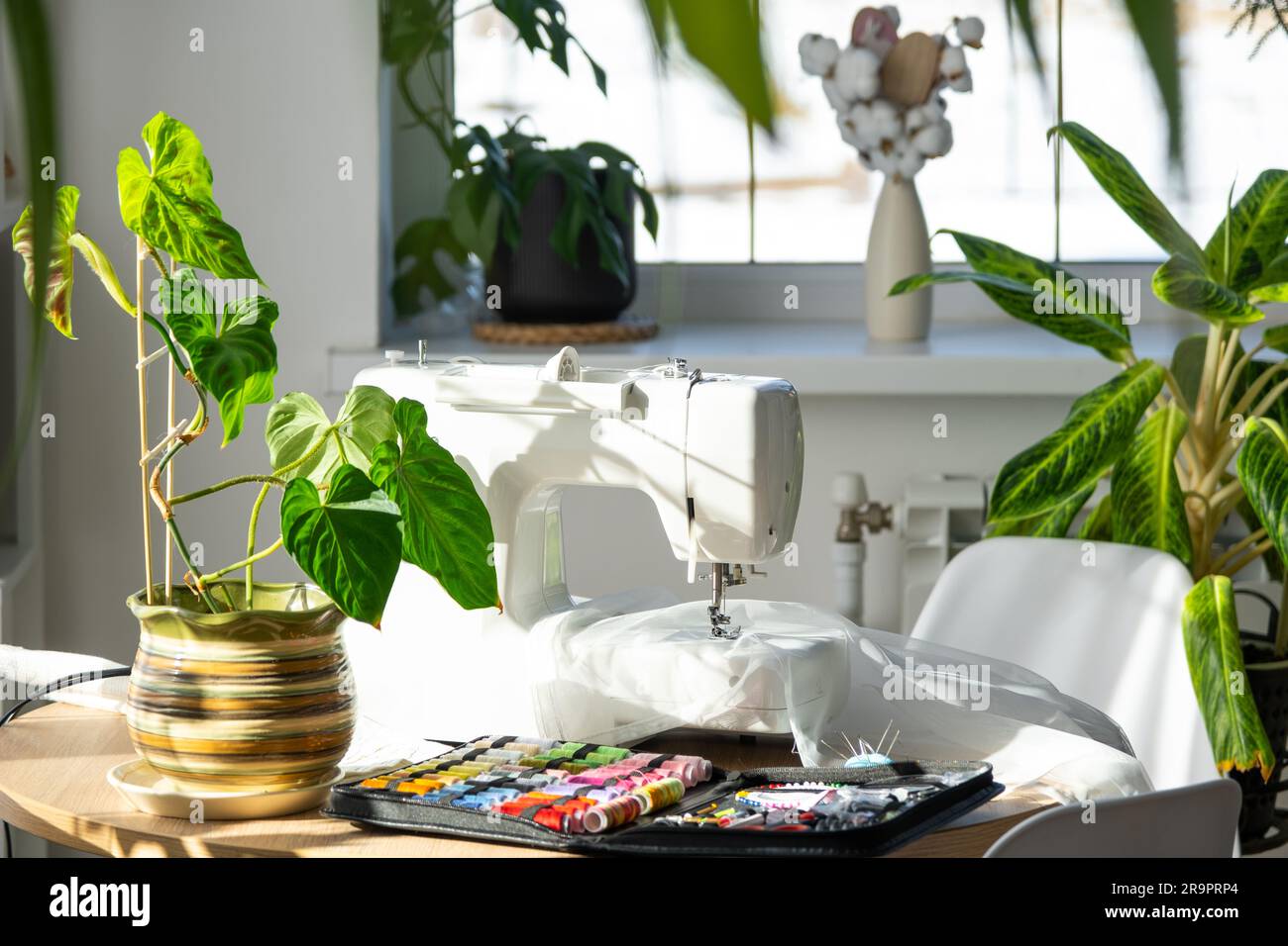 Sewing machine on a round table in the white interior of the house near ...