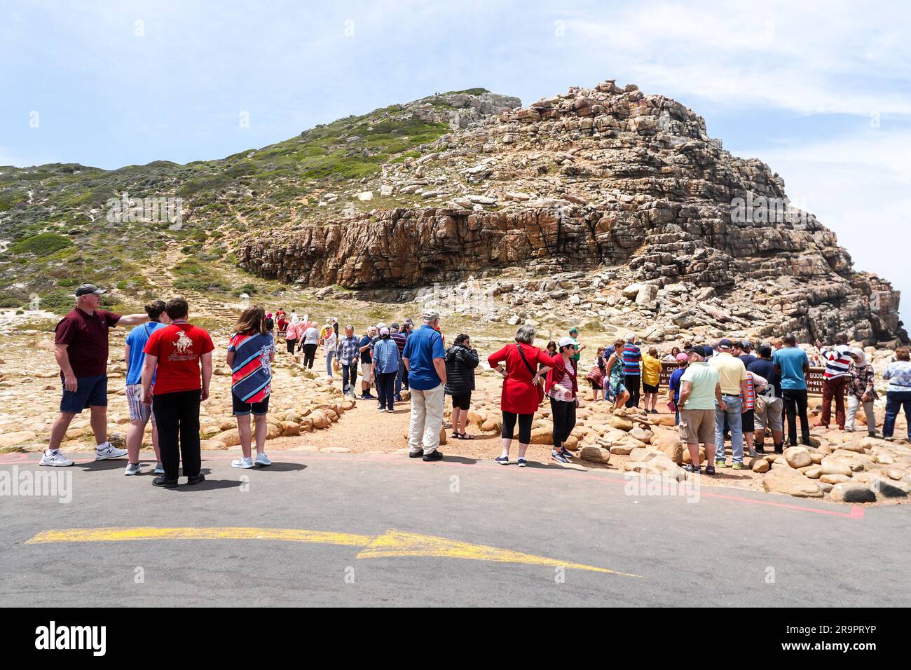 group or crowd of people, tourists standing at the south west tip of Africa to get a photo in ...