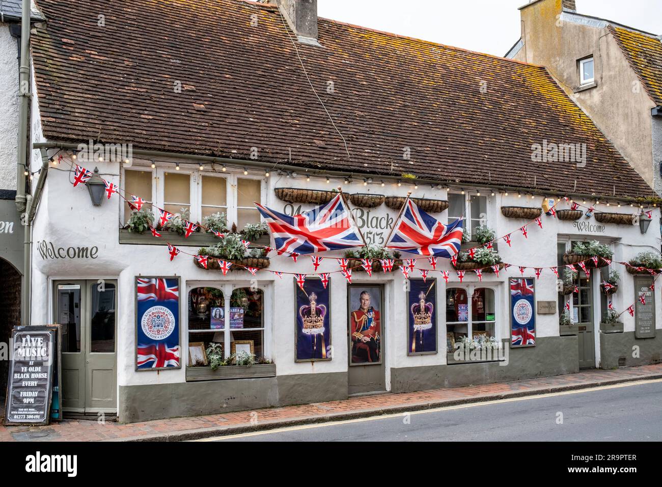The Olde Black Horse Pub Displays Flags and Portraits Of The King On ...